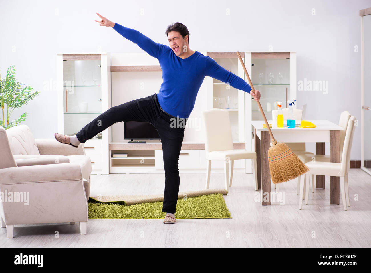 Young man cleaning floor with broom Stock Photo - Alamy