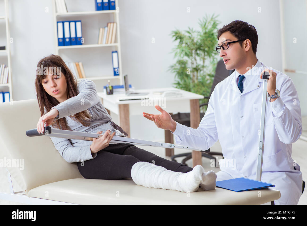 Doctor examining patient with broken leg Stock Photo - Alamy