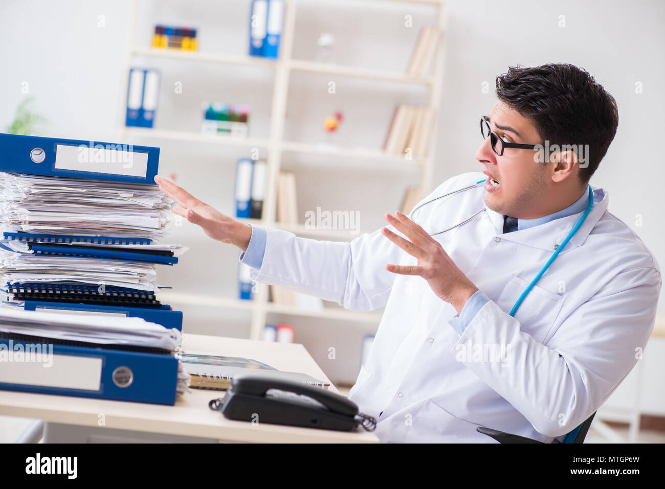 Busy doctor with too much work in hospital Stock Photo - Alamy