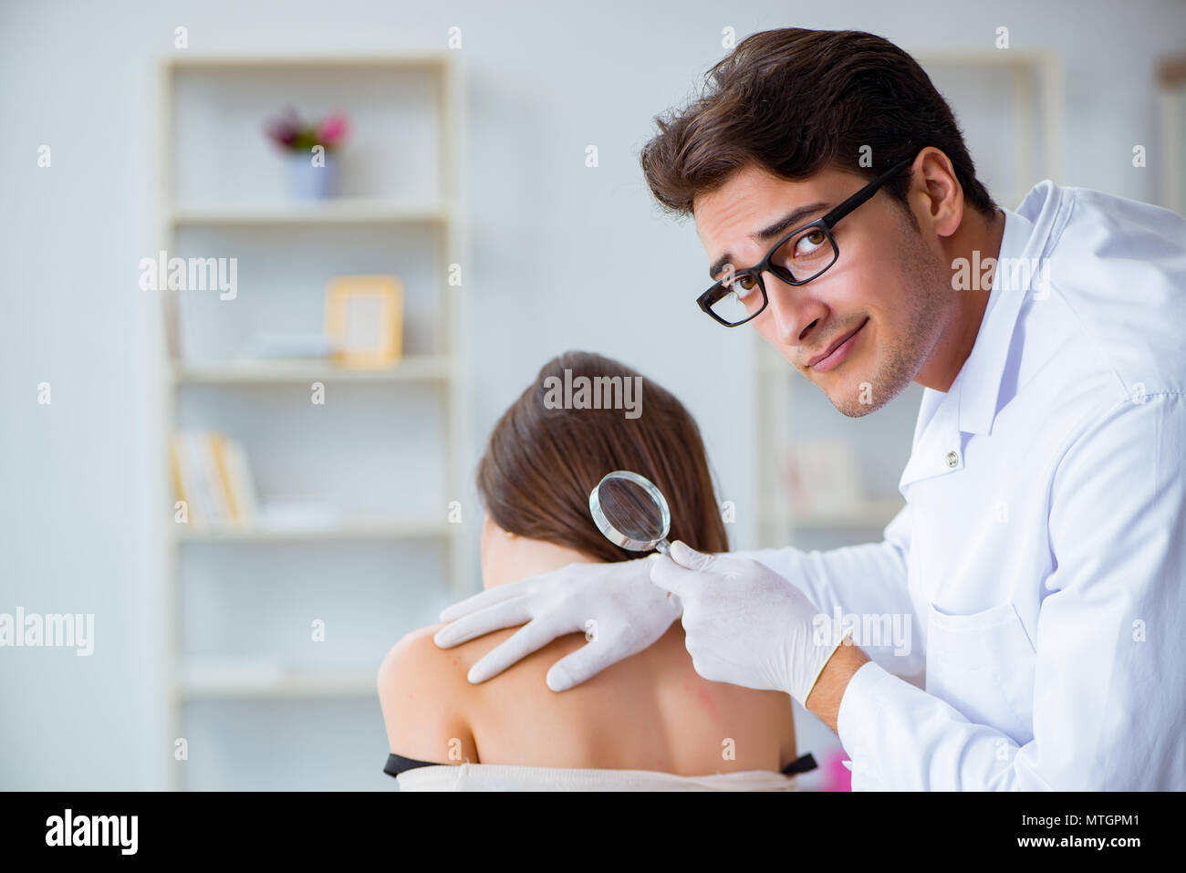 Doctor examining the skin of female patient Stock Photo - Alamy