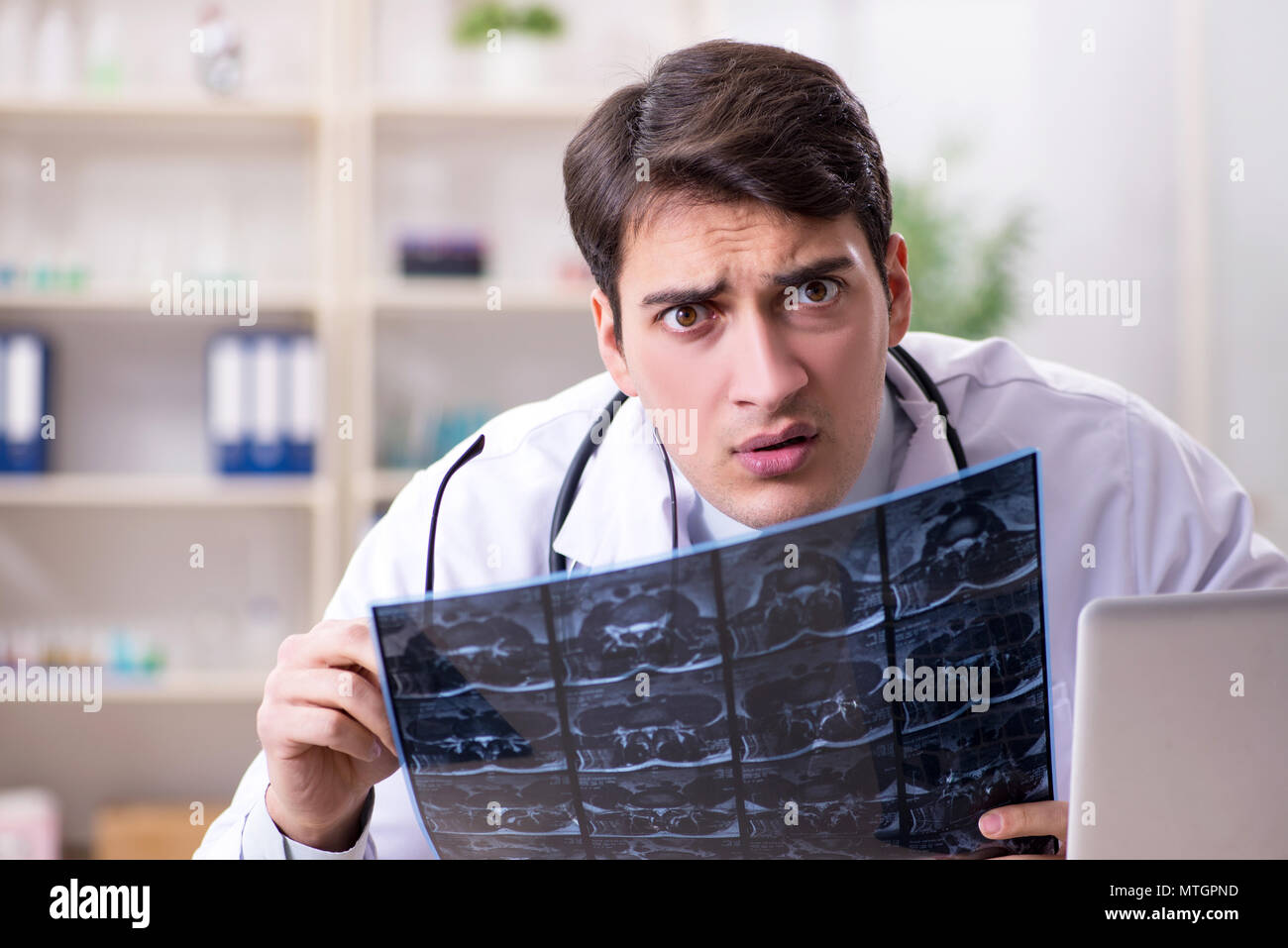 Young doctor looking at x-ray images in clinic Stock Photo - Alamy