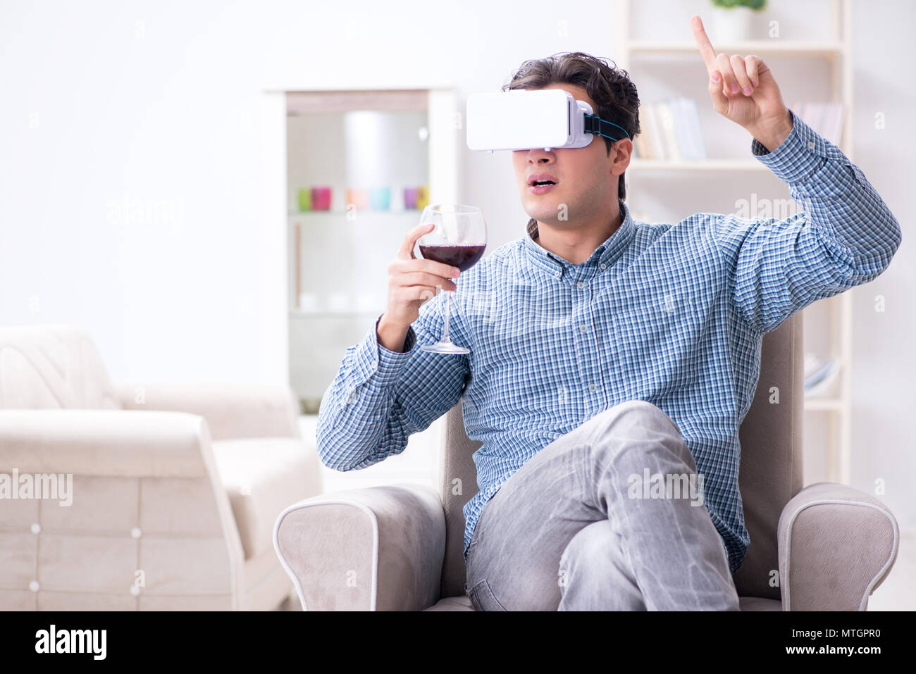 Young man drinking wine at home Stock Photo - Alamy