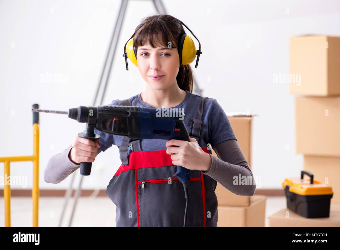 Woman contractor with hand drill at construction site Stock Photo - Alamy