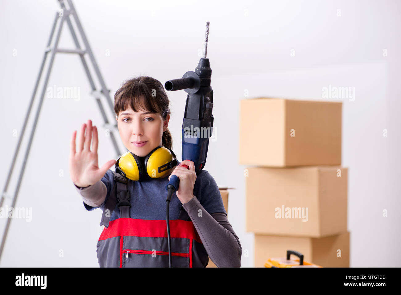 Woman contractor with hand drill at construction site Stock Photo - Alamy