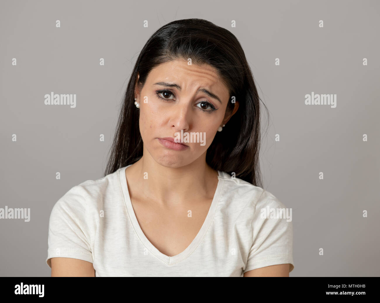 Close up portrait of a beautiful young latin hispanic woman with a sad ...
