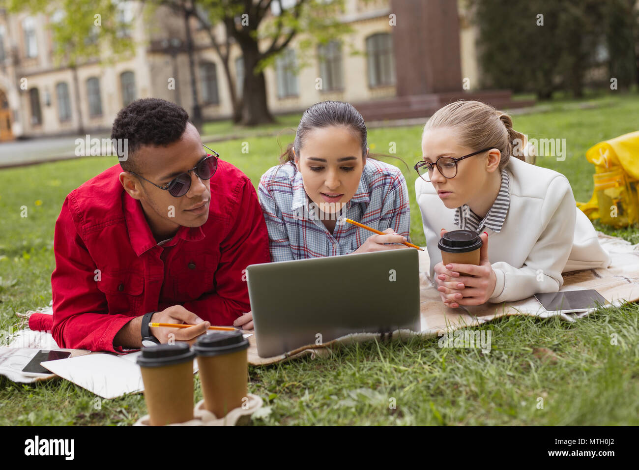 Three smart students preparing for language test together Stock Photo ...