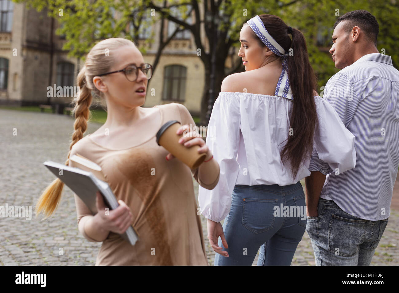 Perplexed student spilling coffee on her shirt Stock Photo - Alamy