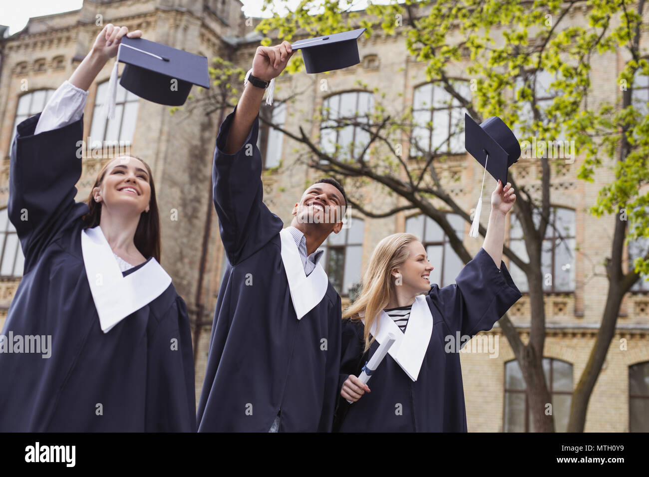 Three students laughing on their graduation day Stock Photo - Alamy