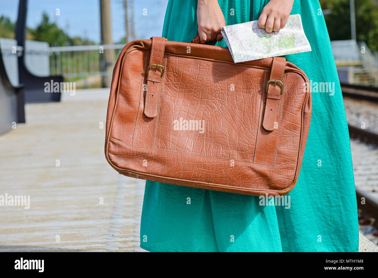 Girl in a holding a map and suitcase at station Stock Photo - Alamy