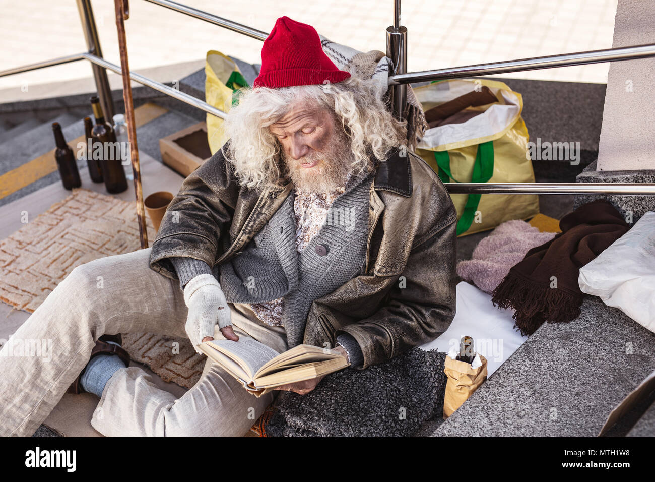 Nice homeless man reading a book Stock Photo - Alamy