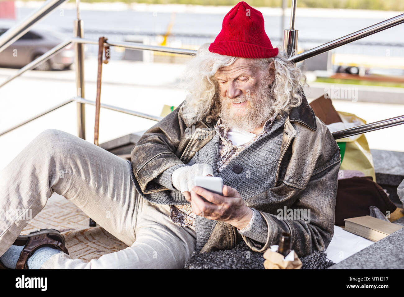 Positive homeless man enjoying new technology Stock Photo - Alamy