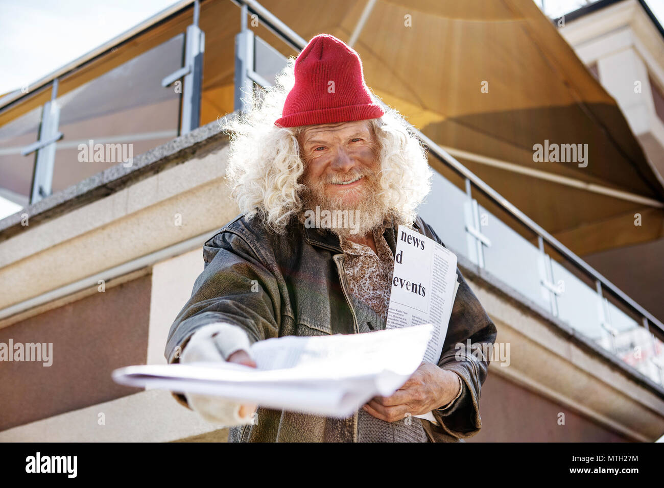 Positive cheerful man giving you a newspaper Stock Photo - Alamy