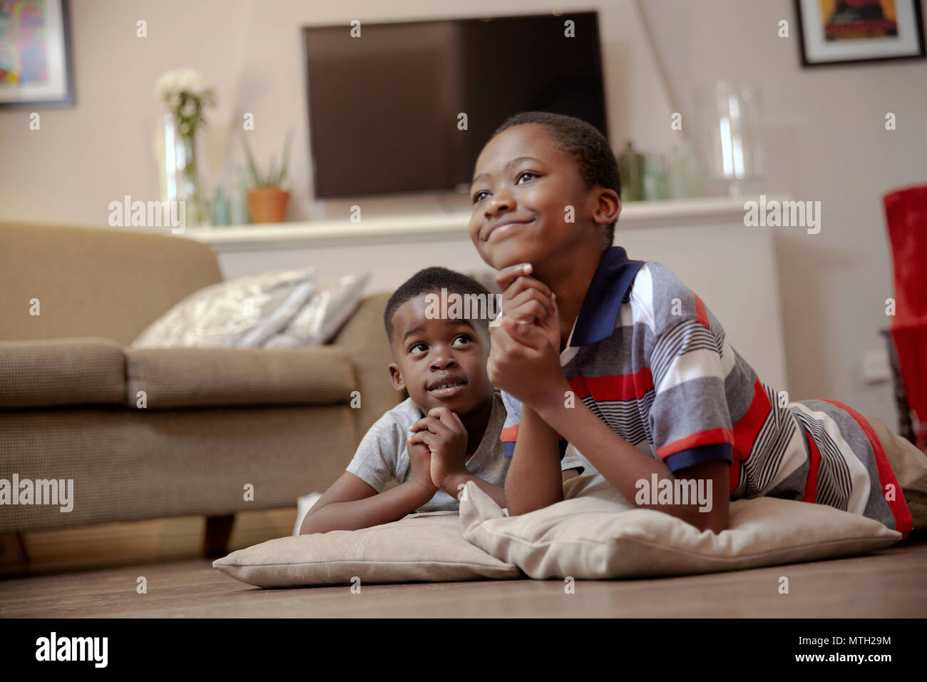 Boys watching TV from the floor Stock Photo - Alamy