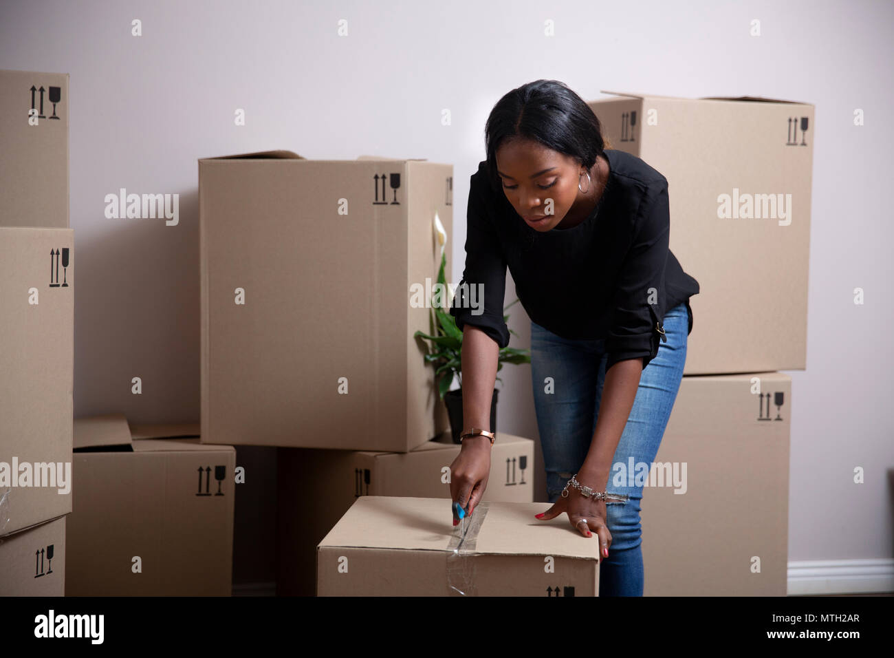 Woman cutting cardboard box open Stock Photo - Alamy