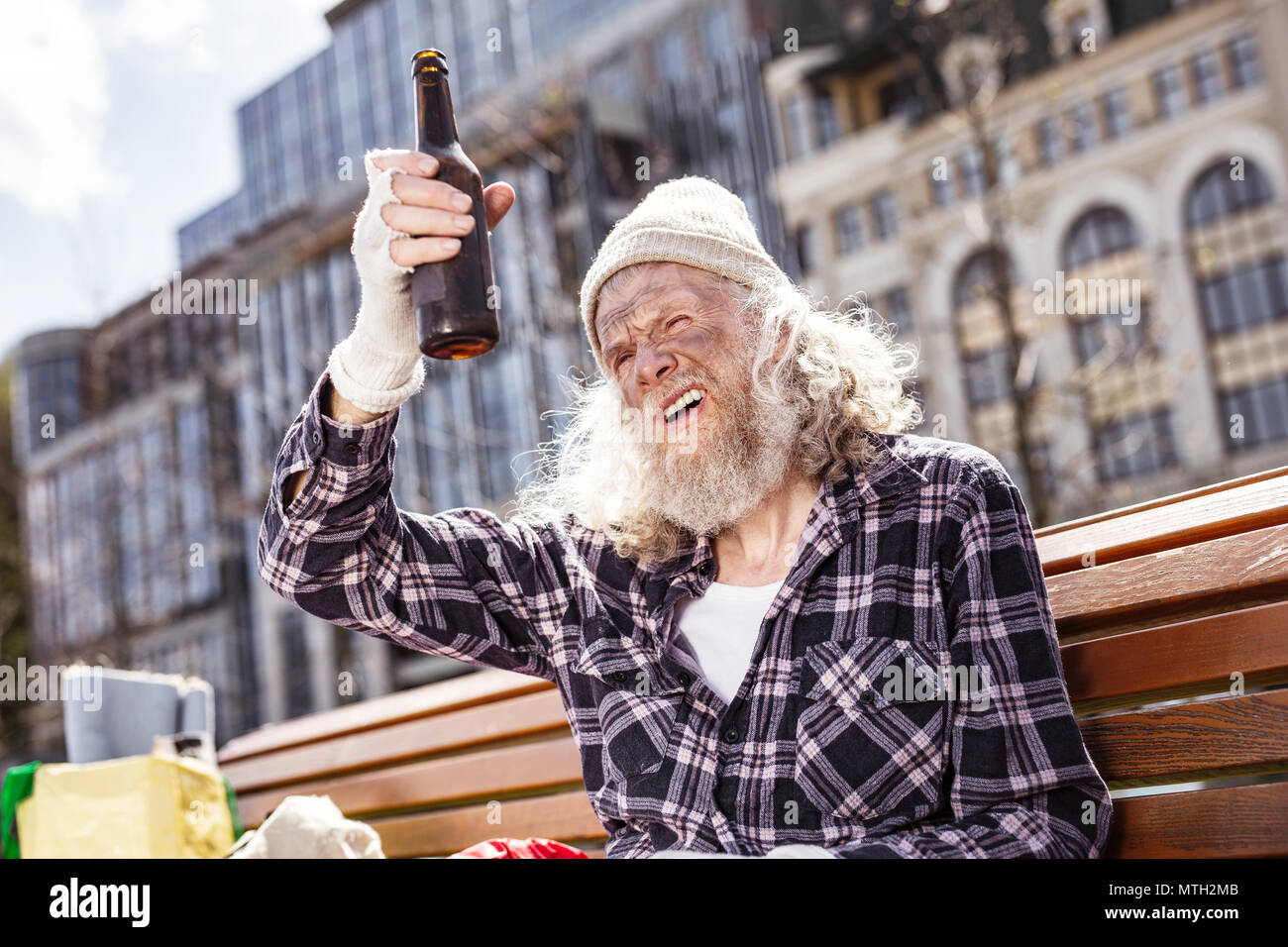 Cheerless drunk man looking at the bottle Stock Photo - Alamy