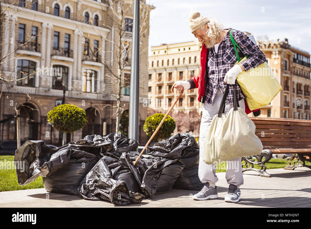 Depressed homeless man looking through the garbage Stock Photo - Alamy