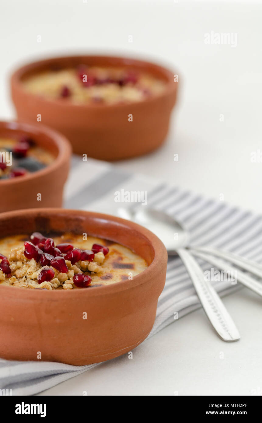 Traditional Turkish oven rice pudding and striped napkin on white ...