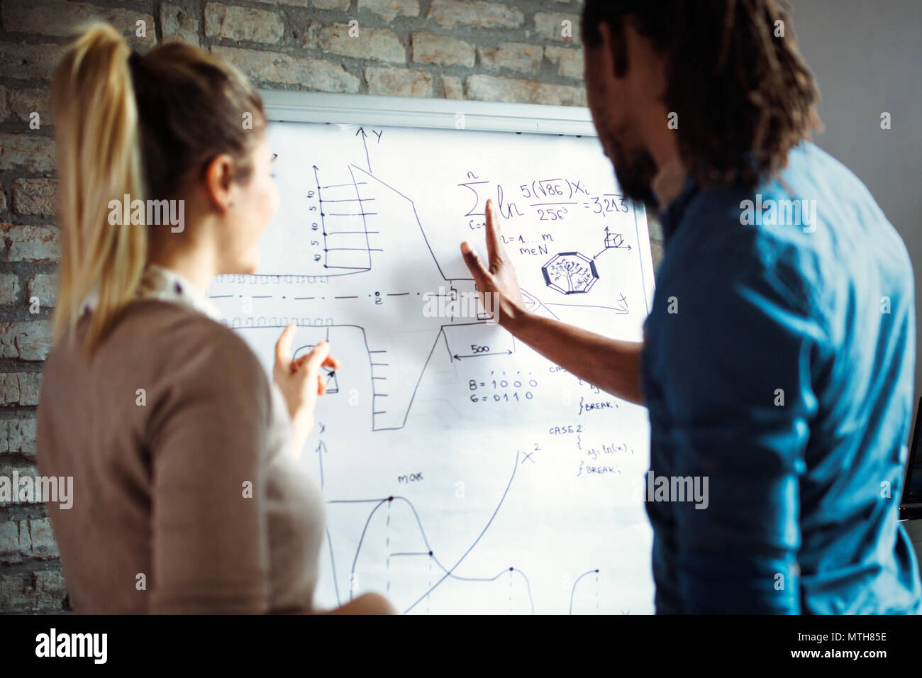 Young architects working on project in office Stock Photo - Alamy