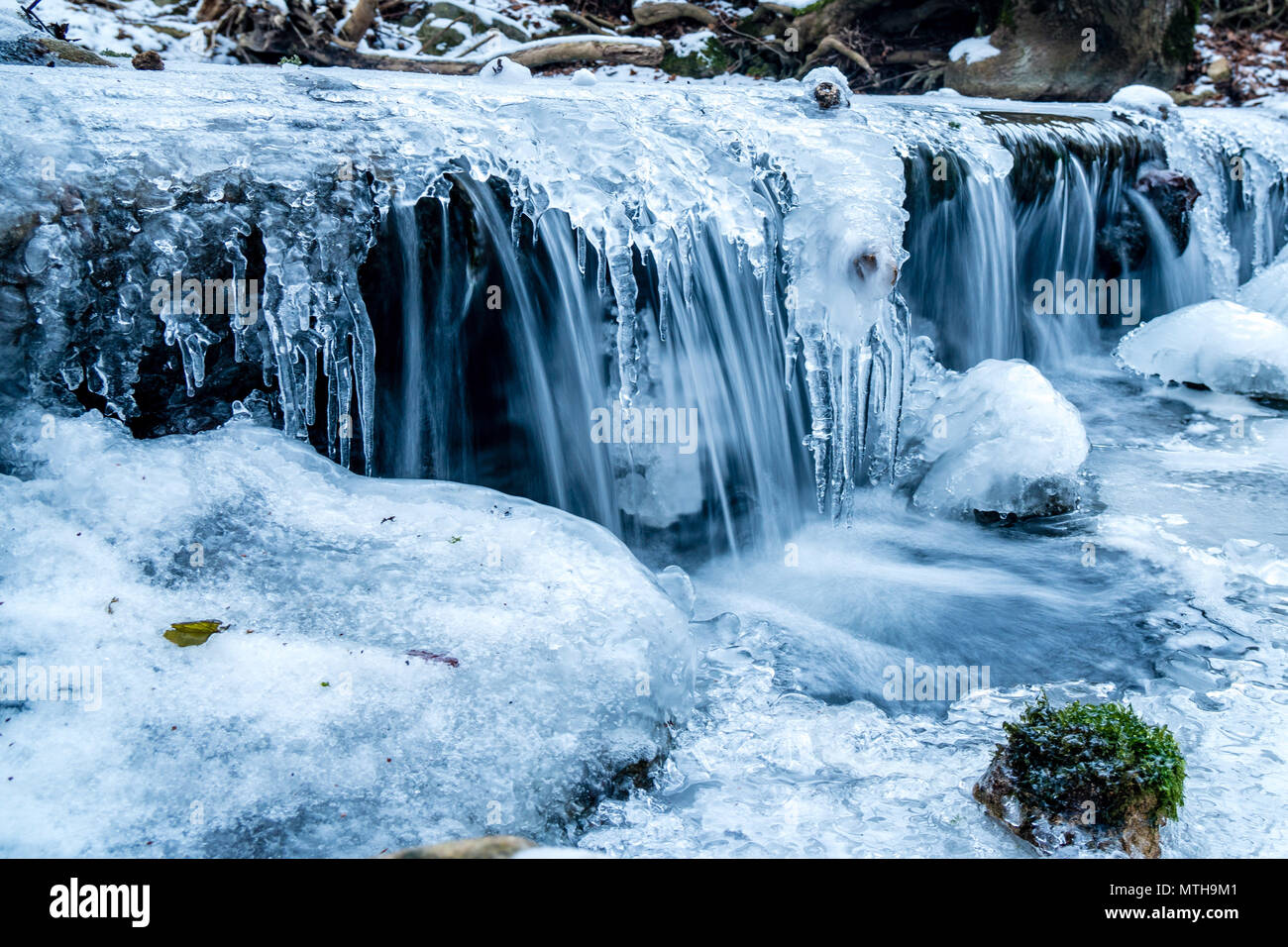 frozen stream little waterfall with moss closeup Stock Photo - Alamy