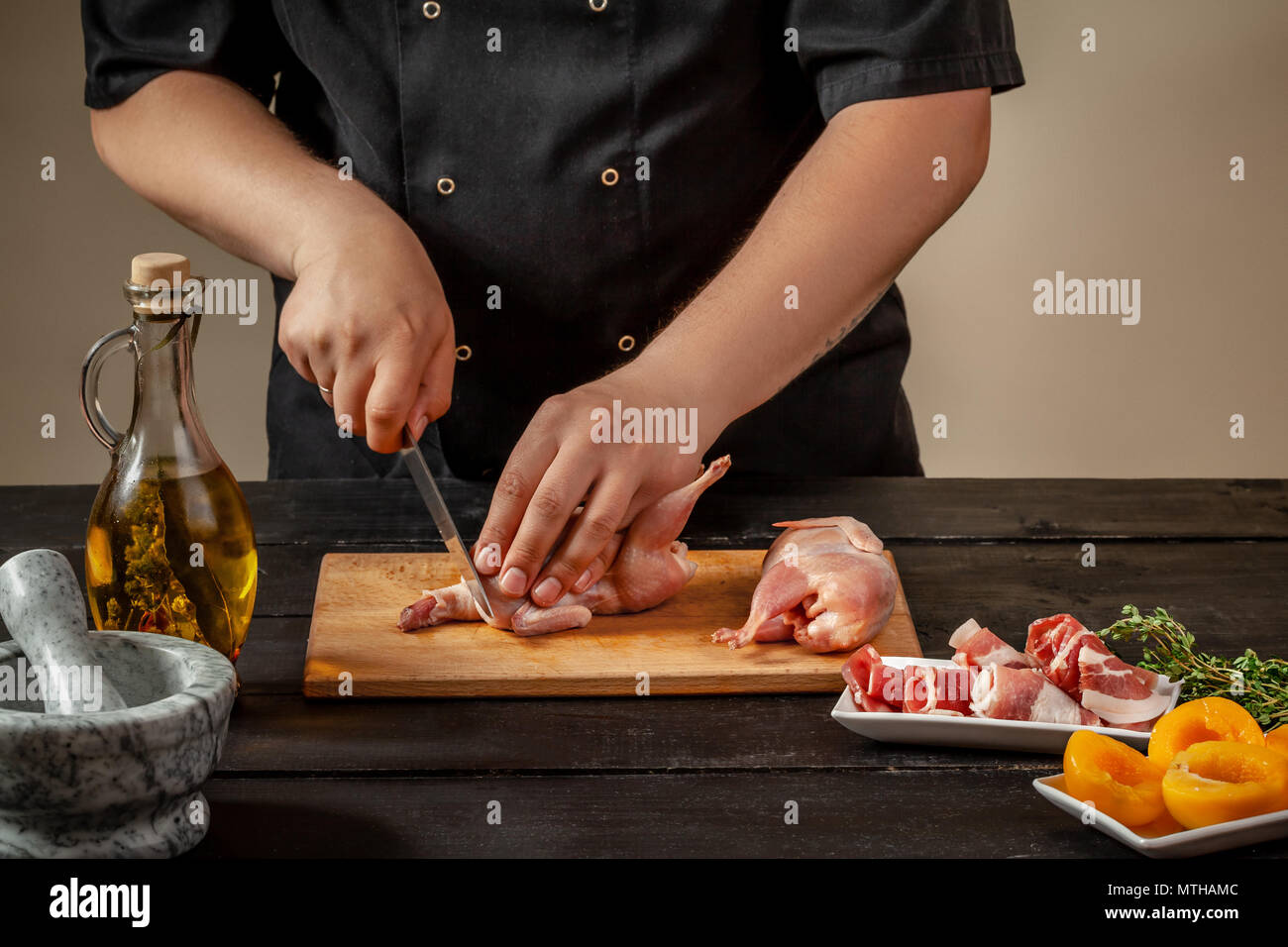 The chef prepares raw quail carcasses in the kitchen. Fresh raw meat ...