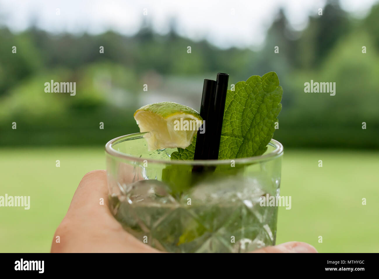 glass of mojito in female hand Stock Photo - Alamy