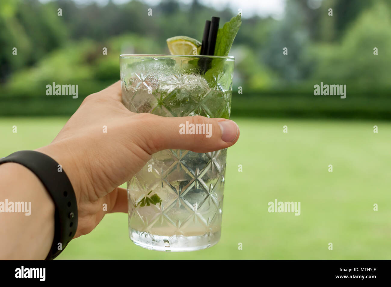 glass of mojito in female hand Stock Photo - Alamy