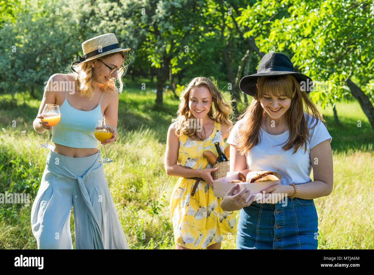Group of girls friends making picnic outdoor. They have fun Stock Photo ...