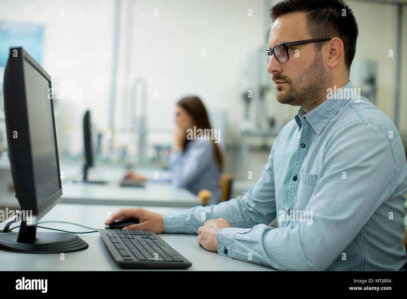 Side view of focused students using desktop pc in classroom at ...