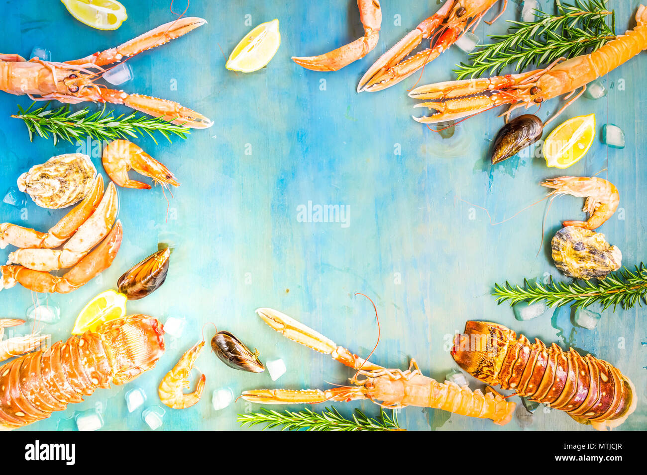 Fresh seafood flat lay frame with copy space on blue wooden background ...