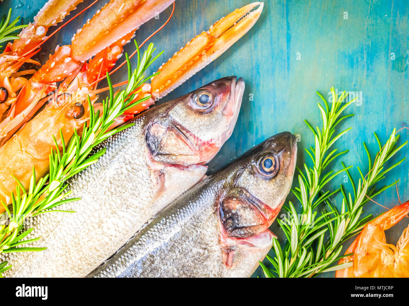 Fresh seafood and fish flat lay scene on blue background close up ...