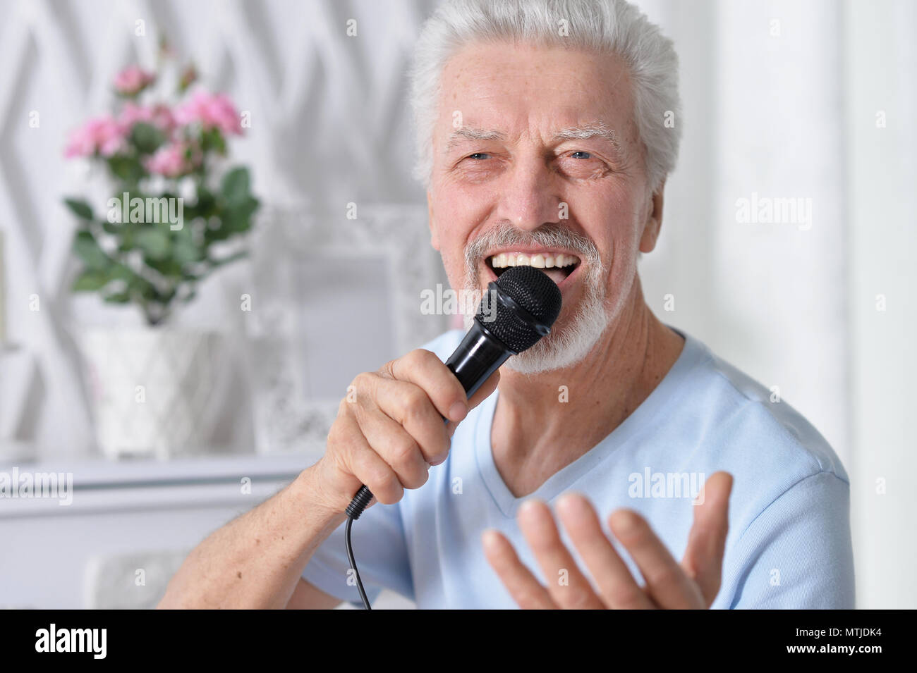 excited senior man holding microphone Stock Photo - Alamy