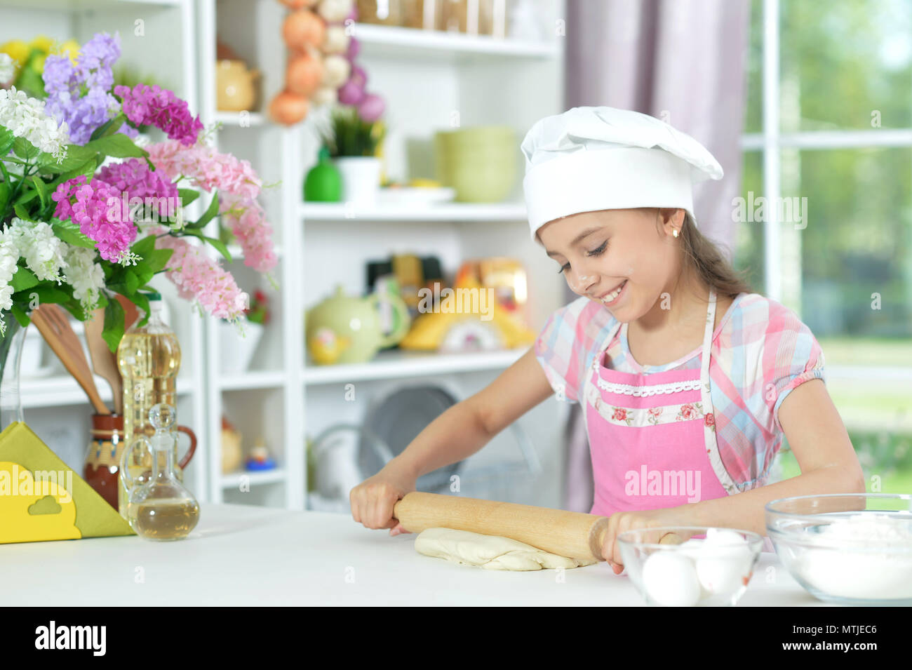 Cute little girl making dinner Stock Photo - Alamy