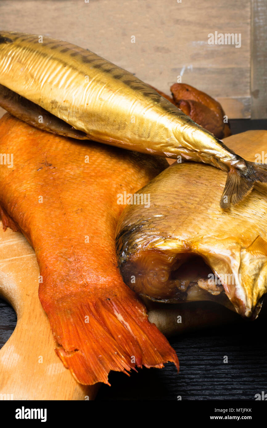 Smoked fish, mackerel, sig, perch and cod roe on the black wooden table ...