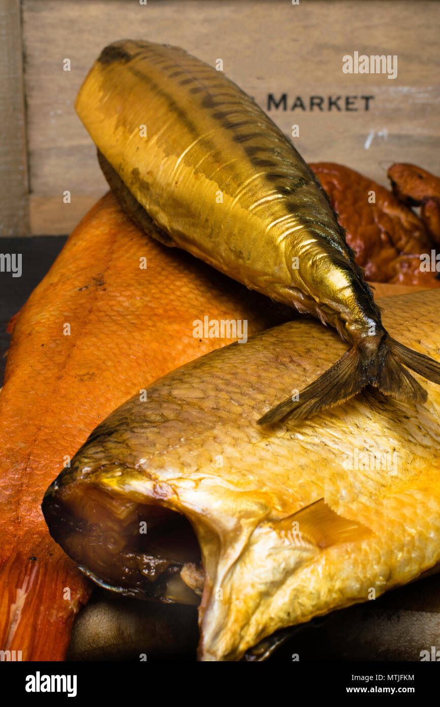 Smoked fish, mackerel, sig, perch and cod roe on the black wooden table ...