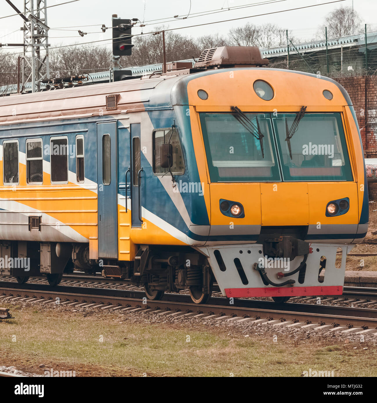 Yellow modern passenger electric train moving at the old terminal Stock ...