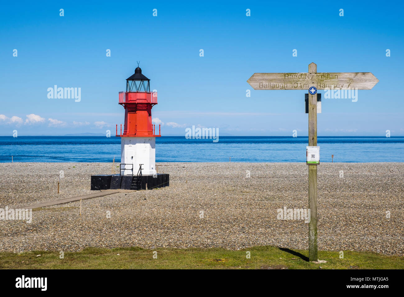 Coastal Path signpost and small lighthouse on shingle beach on northern ...