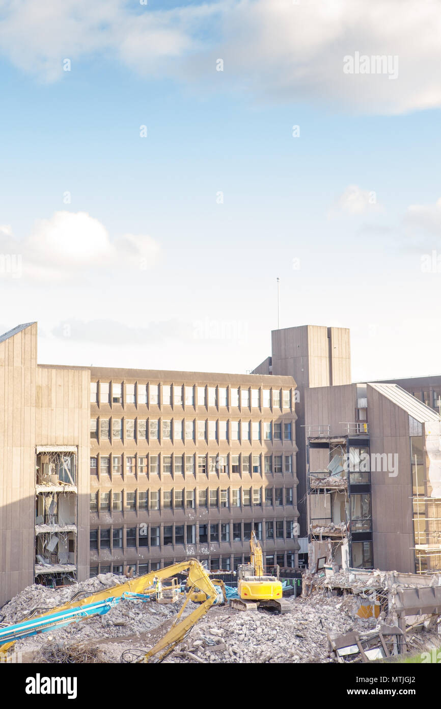 building site with heavy machinery knocking down a building to make way ...