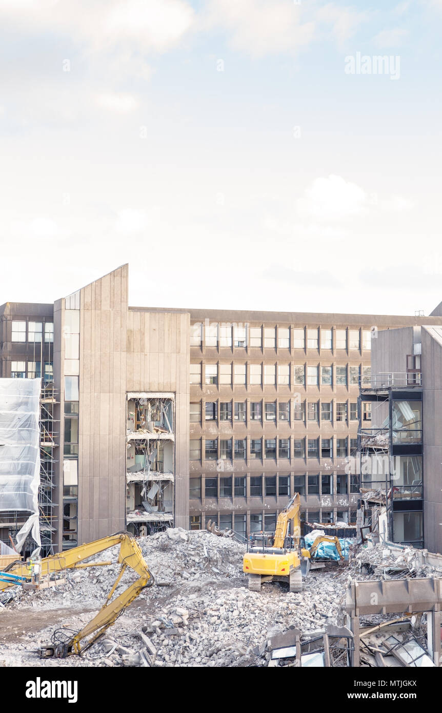 building site with heavy machinery knocking down a building to make way ...