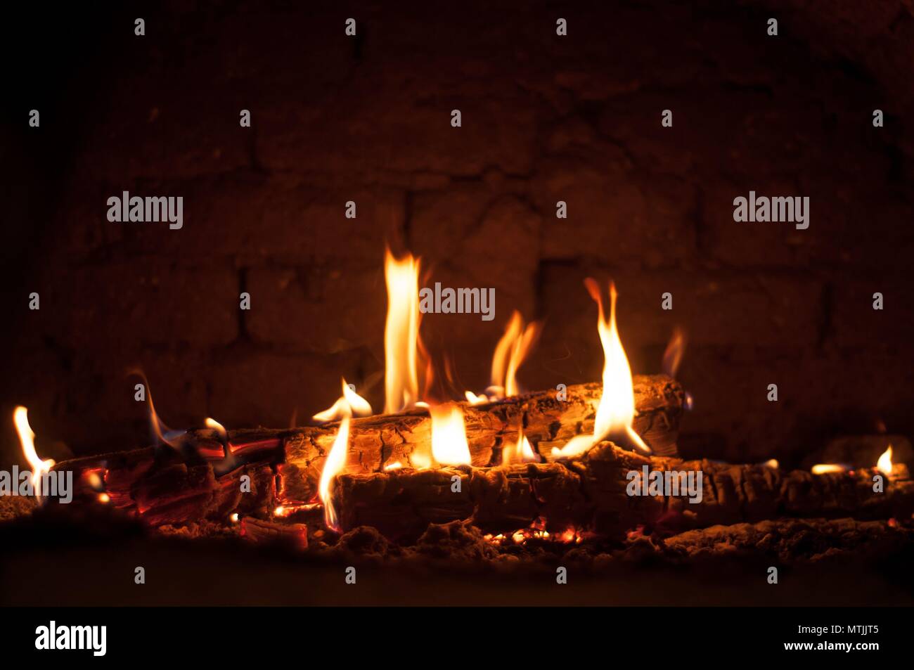 Small fire in the oven against a brick wall background Stock Photo - Alamy