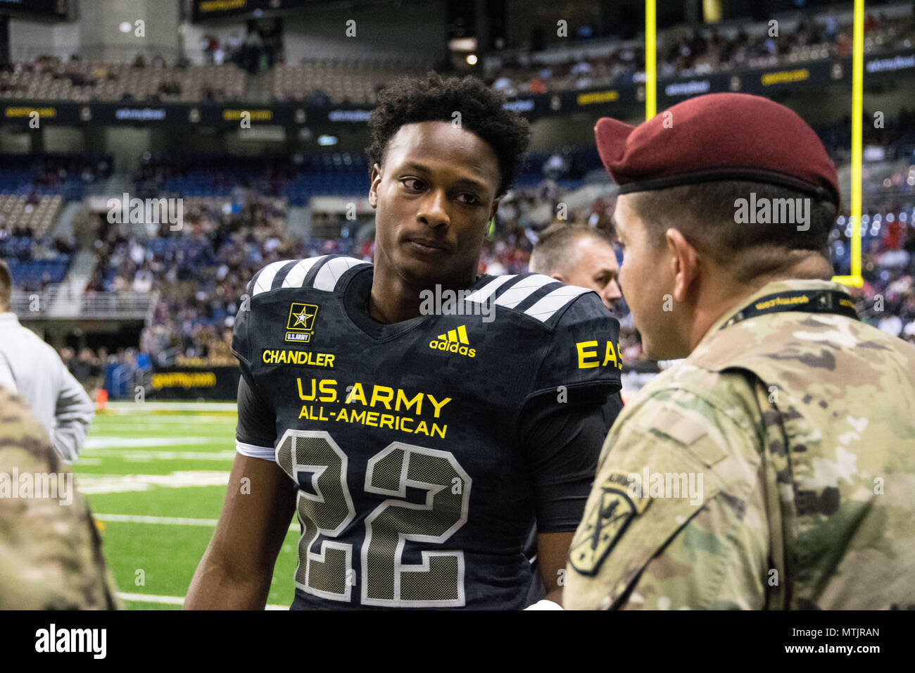 A USASOC Soldier encourages East team running back Ty Chandler, as he ...