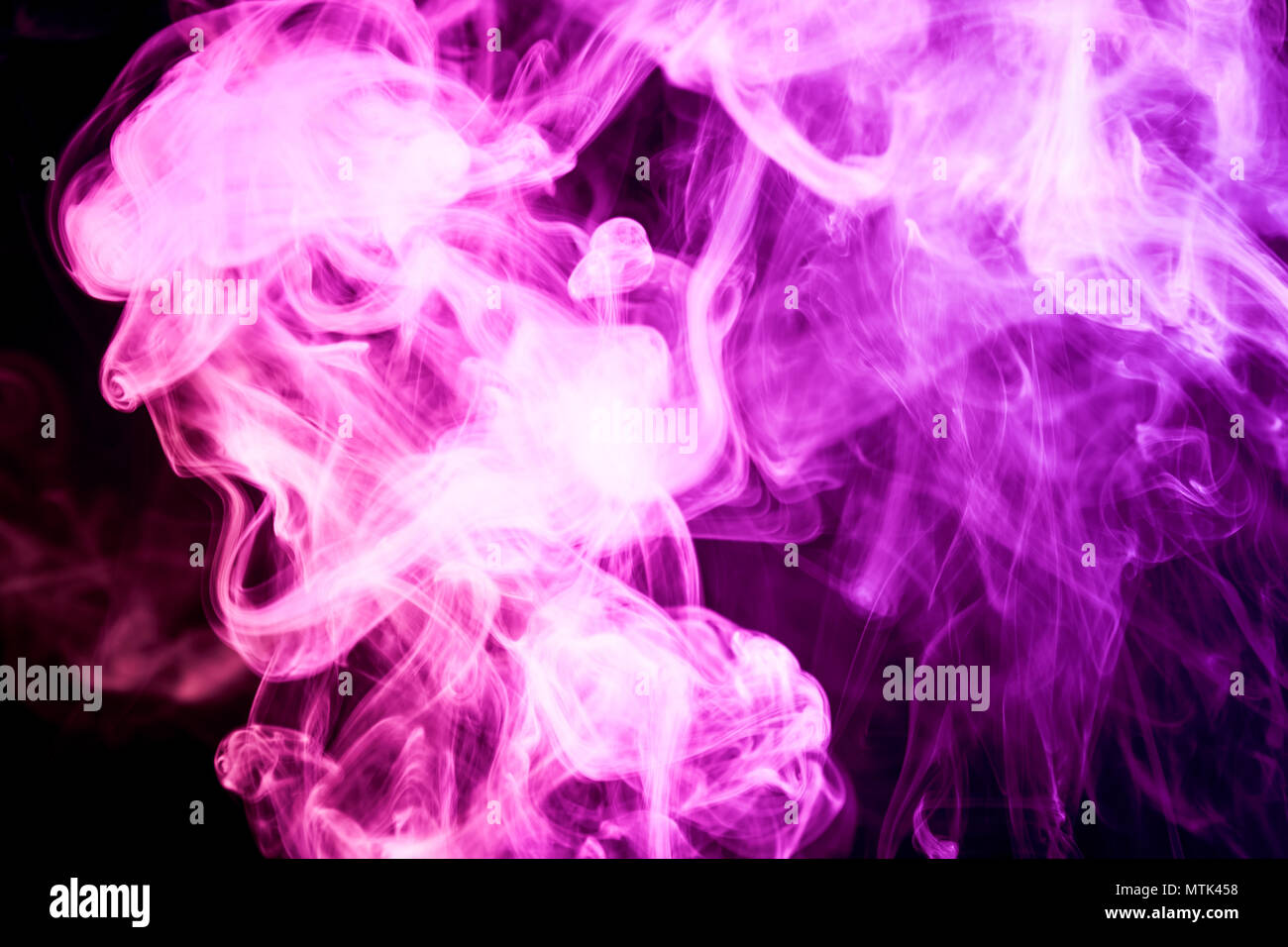 Dense multicolored pink smoke on a black isolated background ...