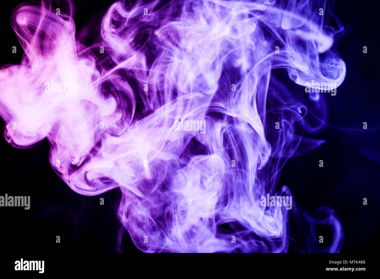 Dense multicolored purple smoke on a black isolated background ...