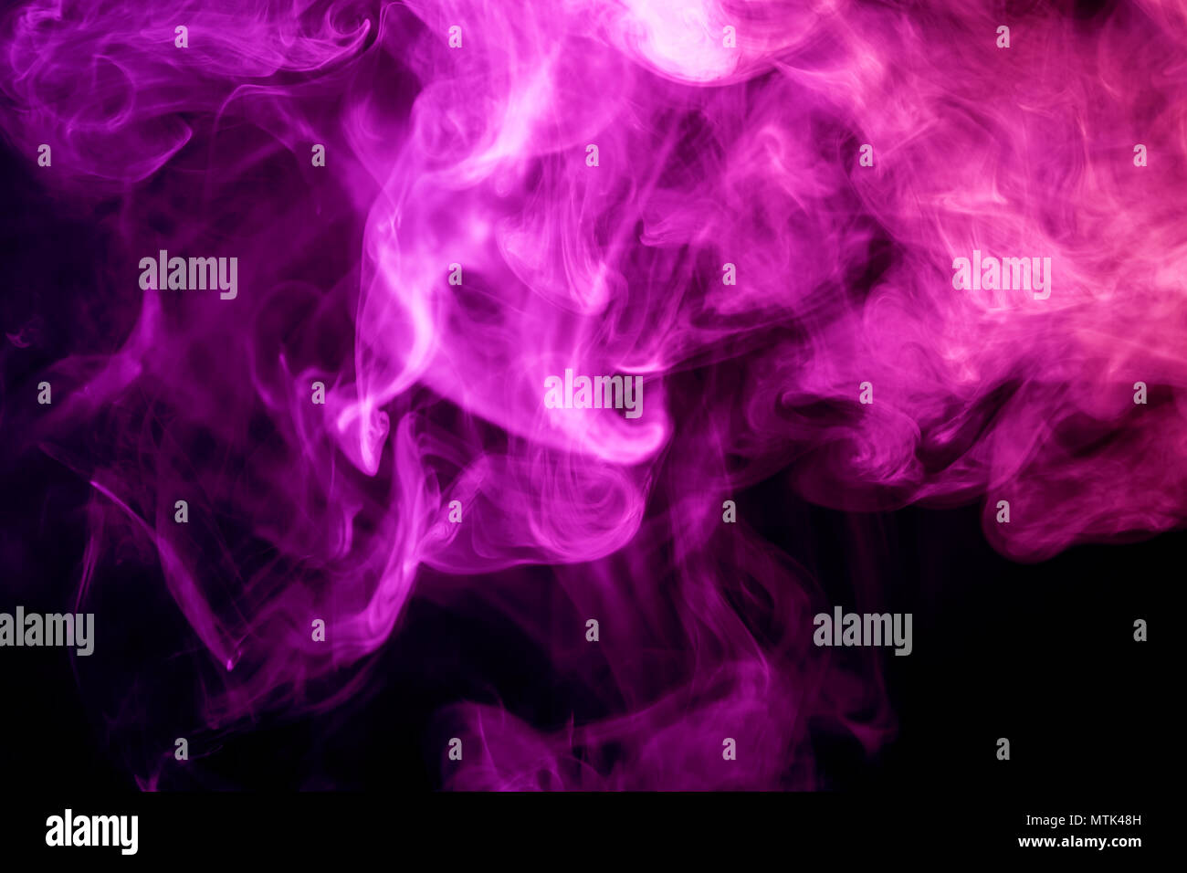 Dense multicolored pink smoke on a black isolated background ...