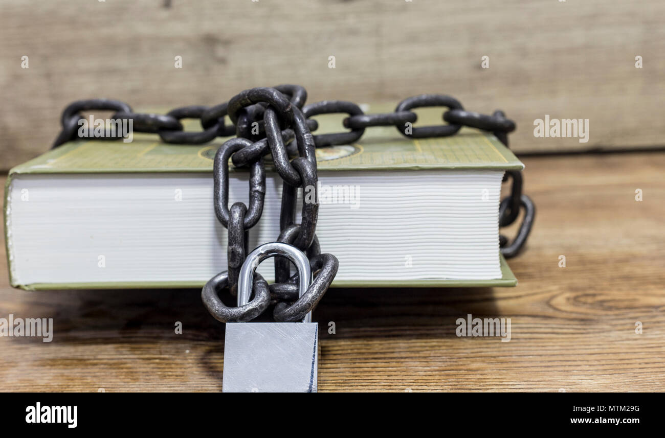 secured book with chain on a wooden background Stock Photo - Alamy