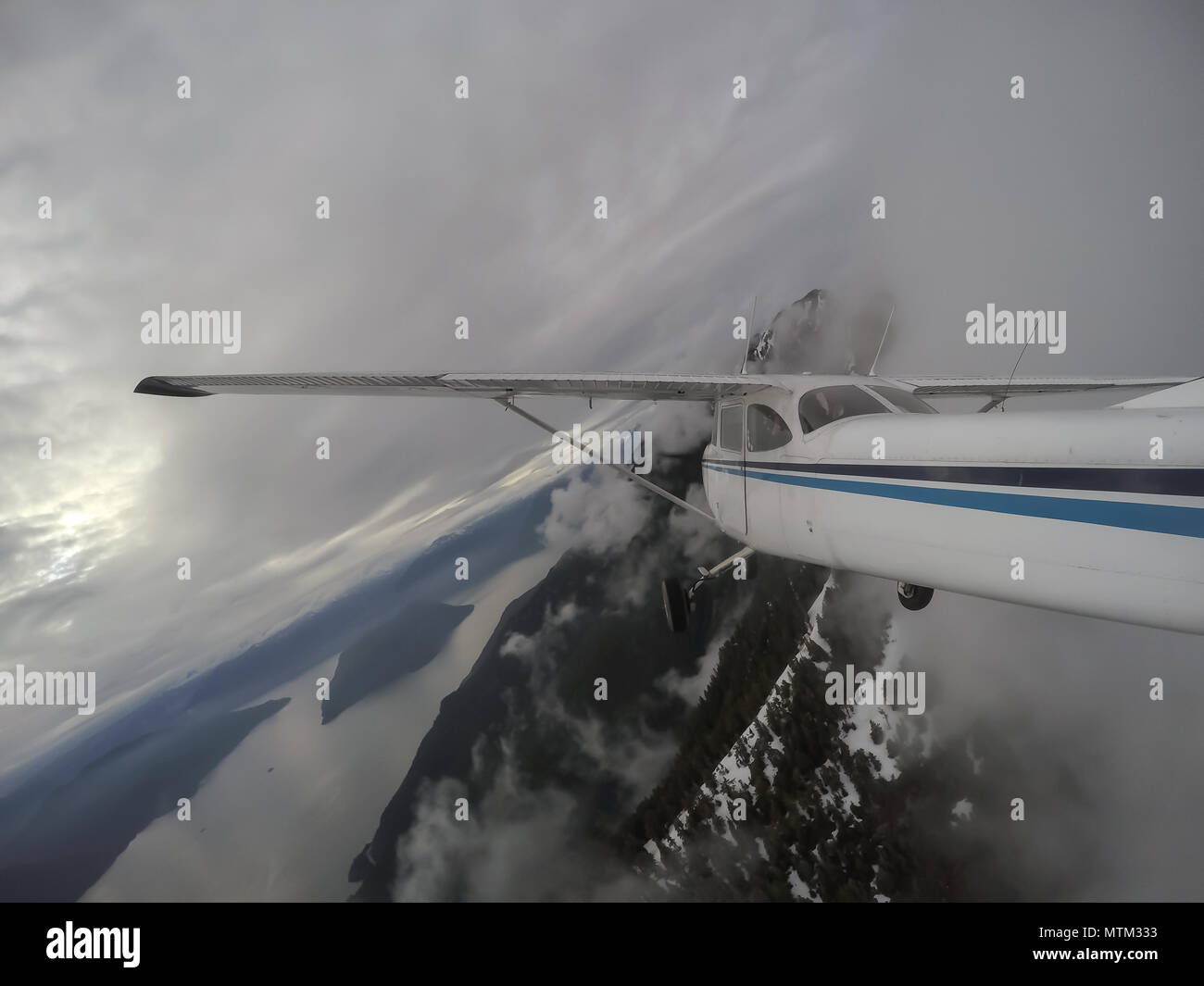 Airplane flying over the beautiful Canadian Mountain Landscape during a ...