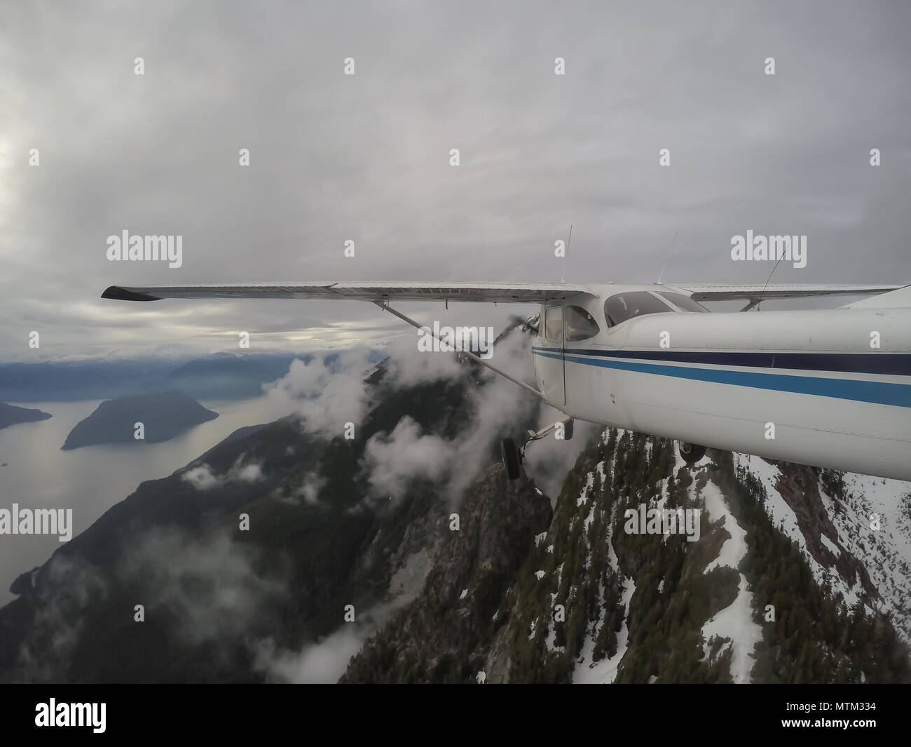 Airplane flying over the beautiful Canadian Mountain Landscape during a ...