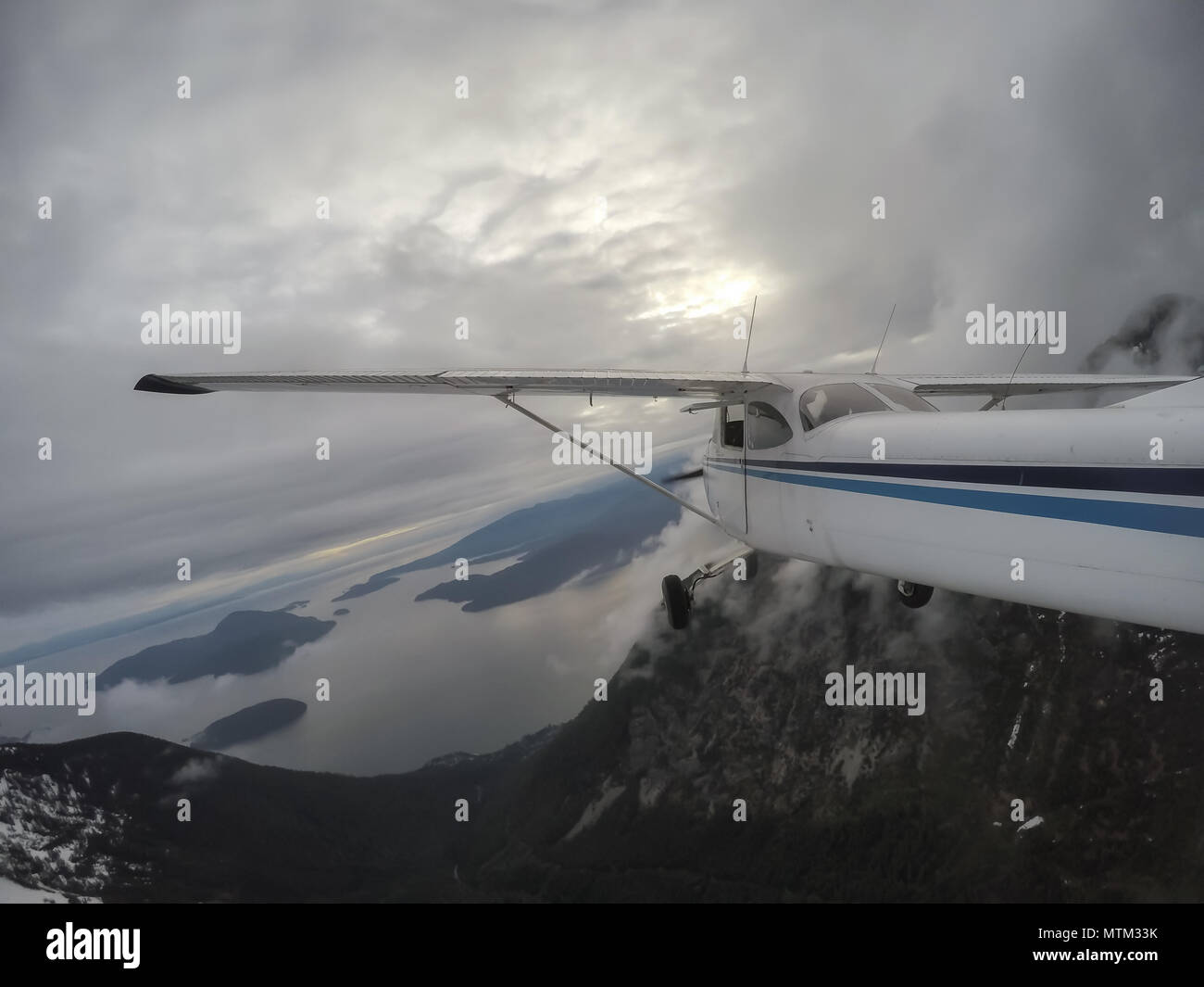 Airplane flying over the beautiful Canadian Mountain Landscape during a ...