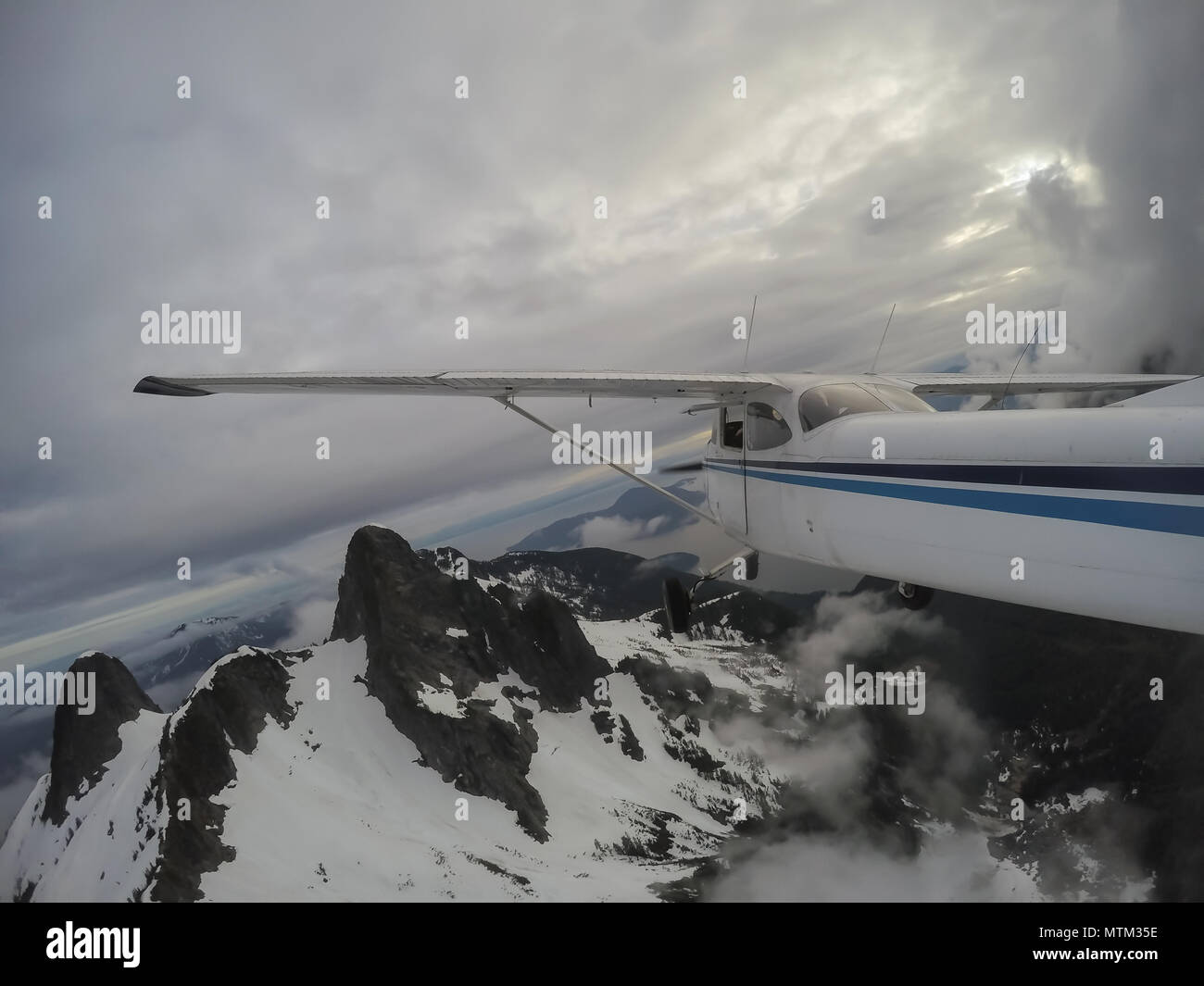 Airplane flying over the beautiful Canadian Mountain Landscape during a ...