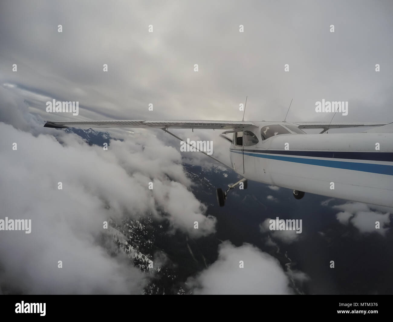Airplane flying over the beautiful Canadian Mountain Landscape during a ...