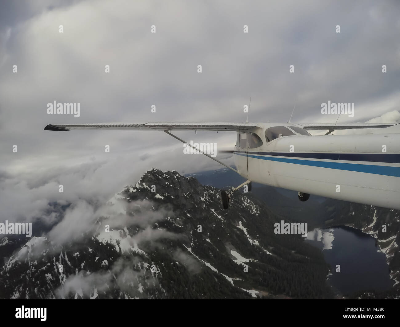 Airplane flying over the beautiful Canadian Mountain Landscape during a ...